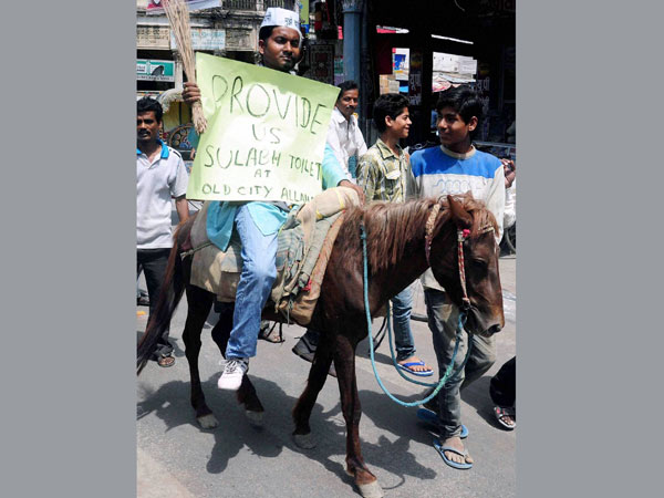 AAP worker rides donkey demanding public toilet, booked - Oneindia News
